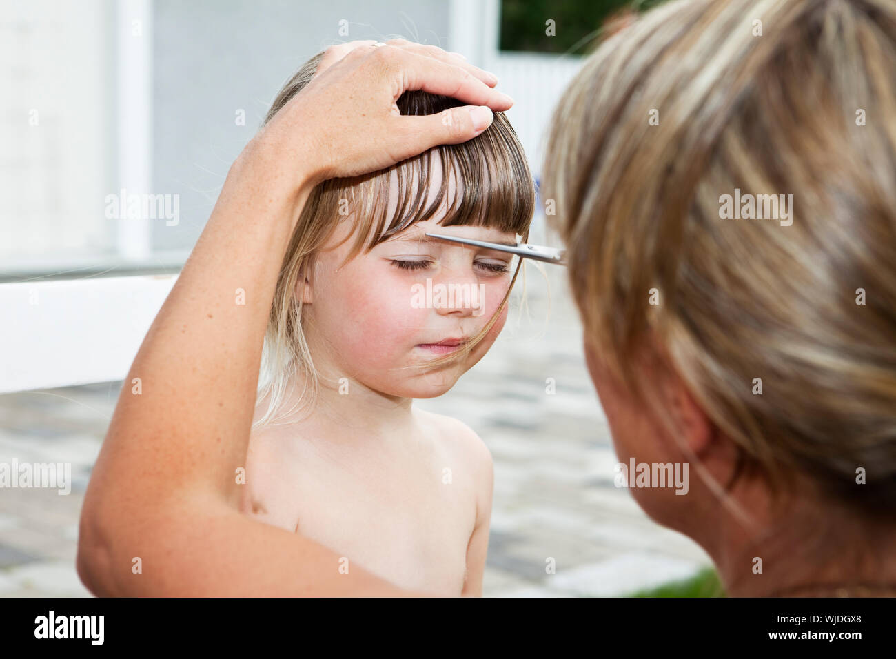 Woman cutting young girls hair outdoor Stock Photo - Alamy
