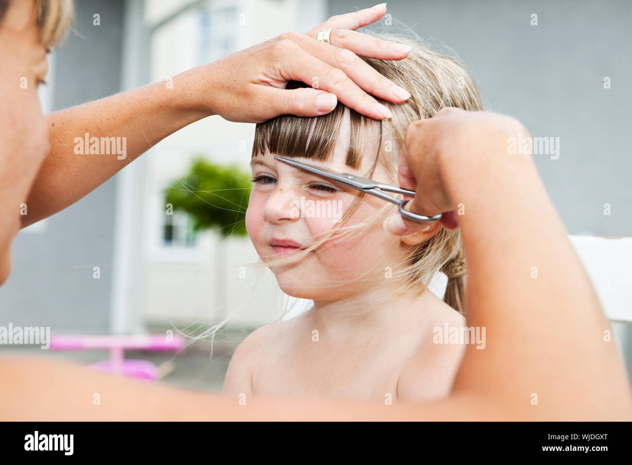 Woman cutting young girls hair Stock Photo - Alamy