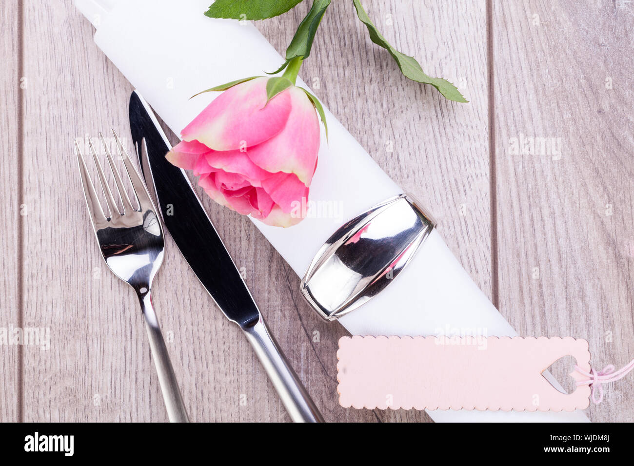 Table setting with a single pink rose Stock Photo - Alamy