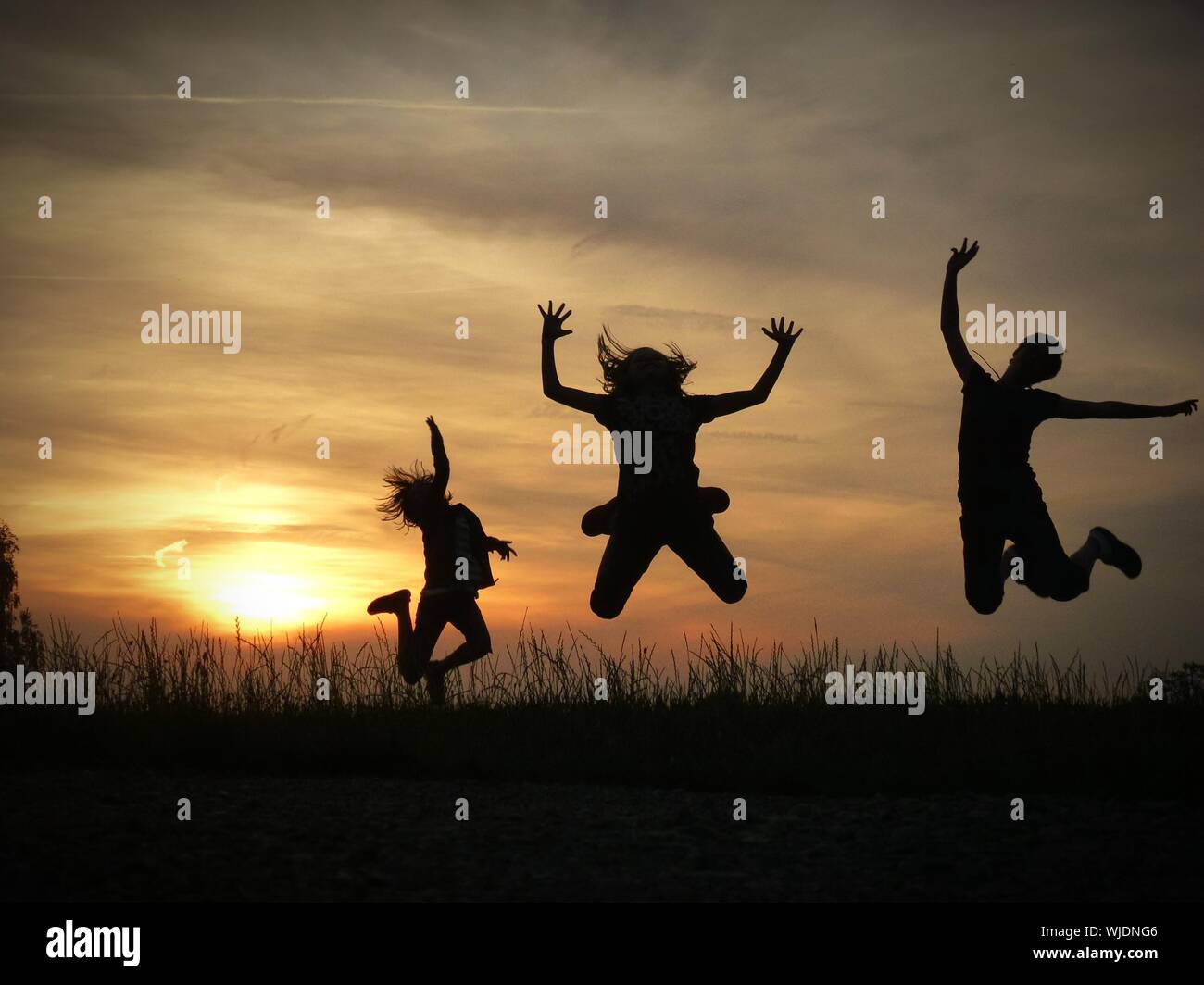 Silhouettes Of People Jumping At Sunset Stock Photo - Alamy