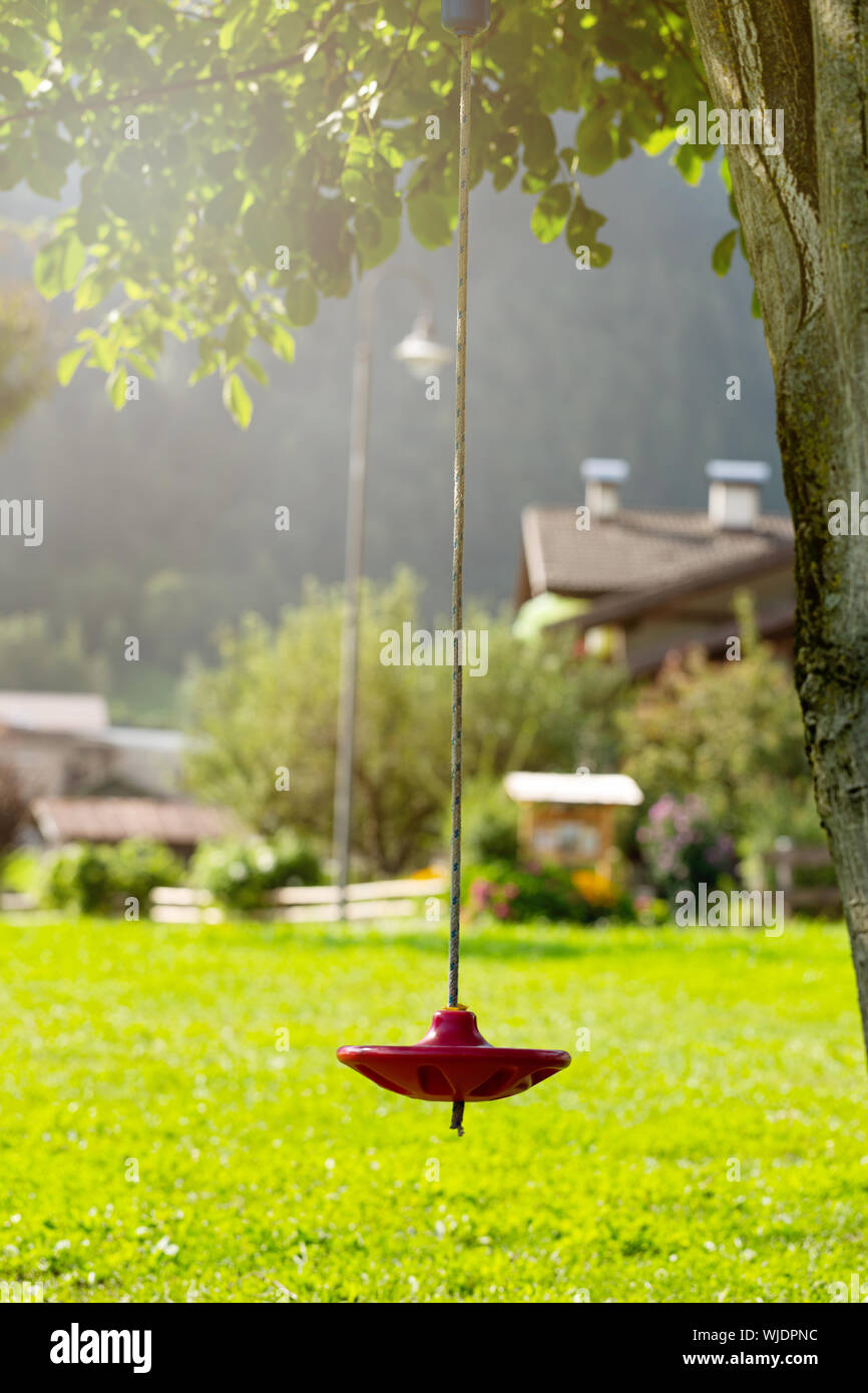 Round red swing for children on a tree Stock Photo - Alamy