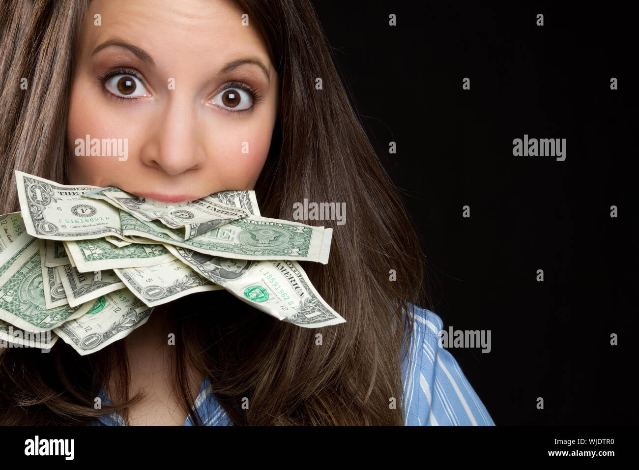 Woman eating money in mouth Stock Photo - Alamy
