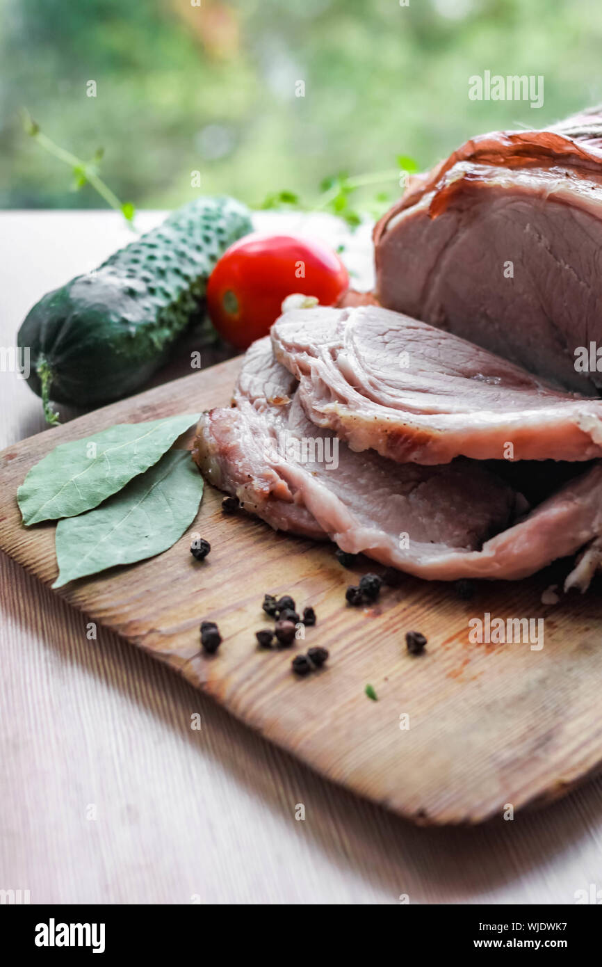 Homemade baked pork ham with aromatic herbs, cucumber and tomato ...
