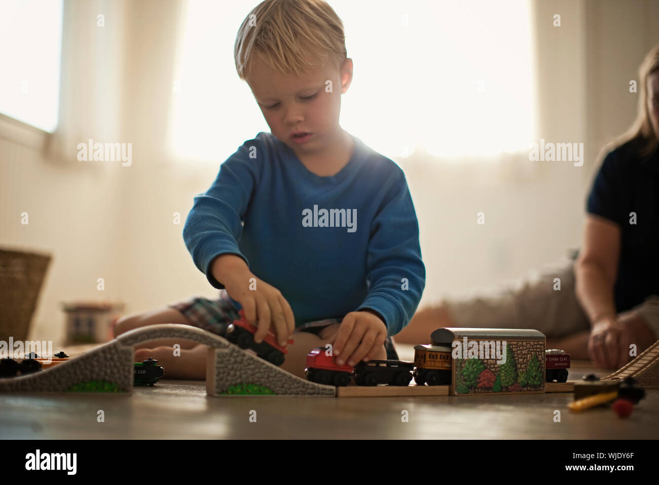 Little boy playing with train set Stock Photo - Alamy