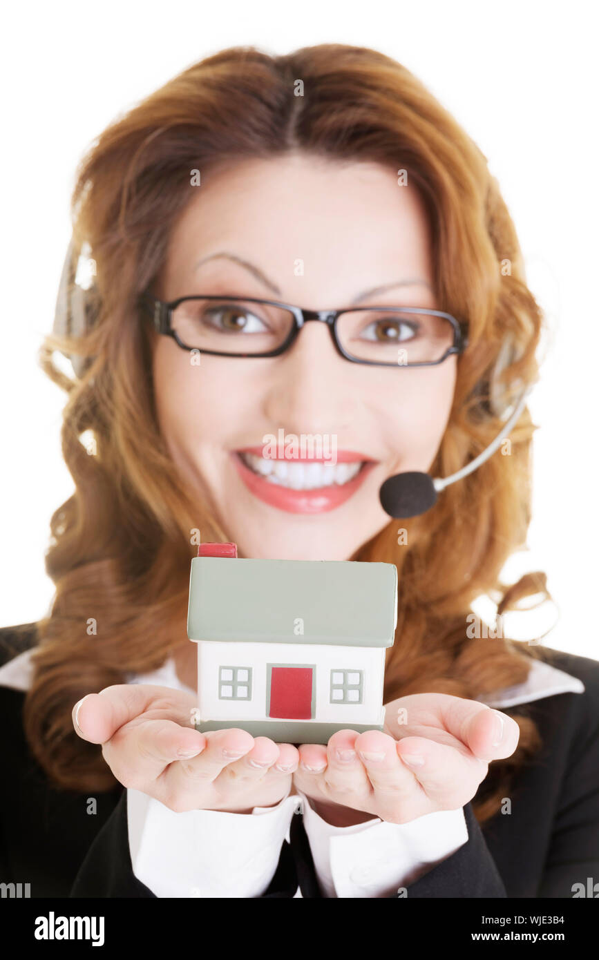 Attractive call center support woman with headset andhouse model in ...