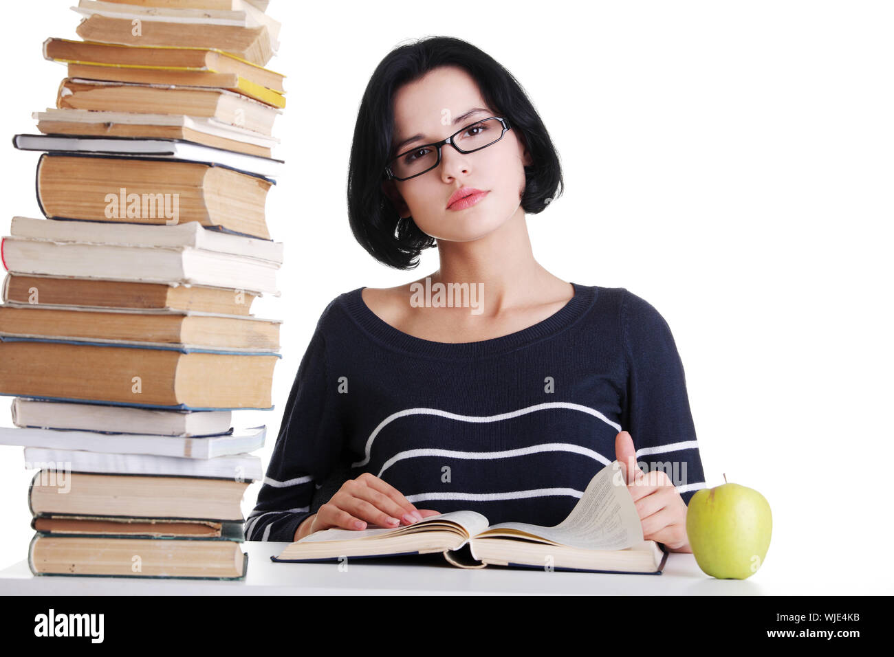 Young student woman with books studying at the desk, isolated on white ...