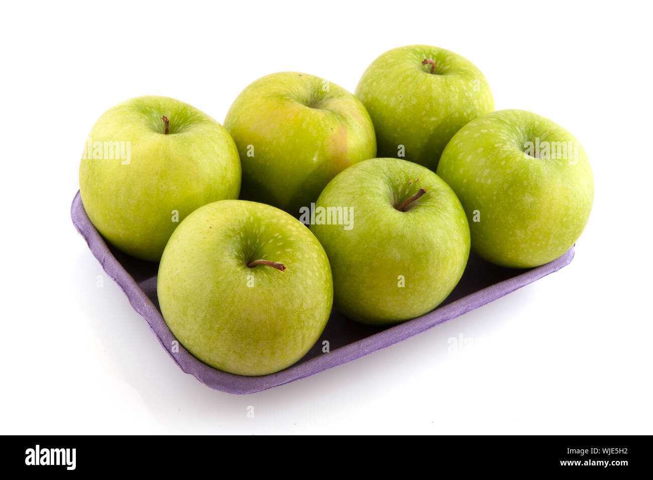 Tray fresh green apples isolated over white Stock Photo - Alamy