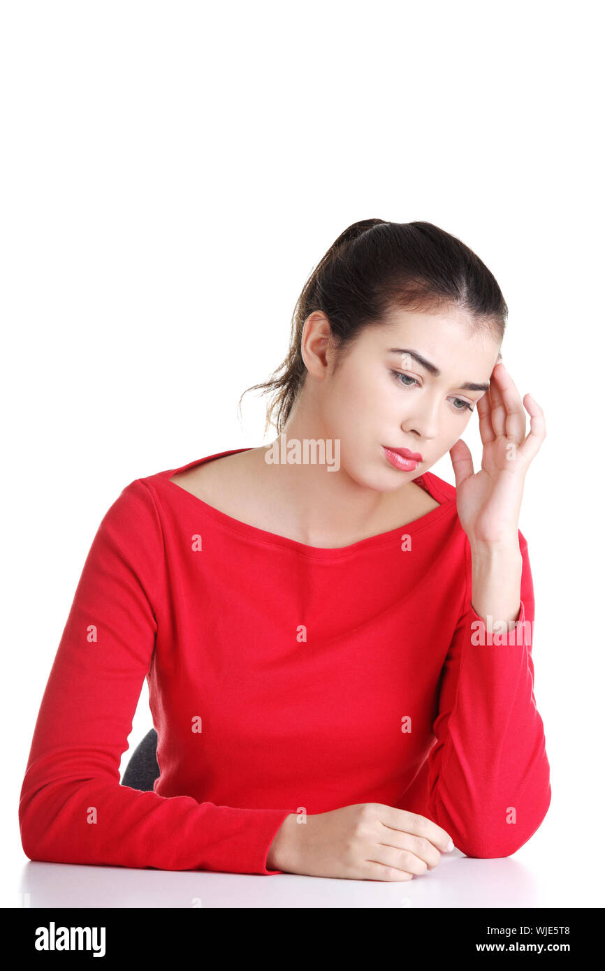 Girl sitting with resigned position. Bored young woman touching her ...