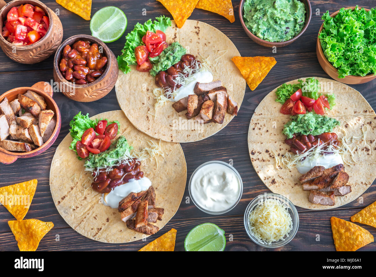 Tacos with fillings on the wooden table Stock Photo - Alamy