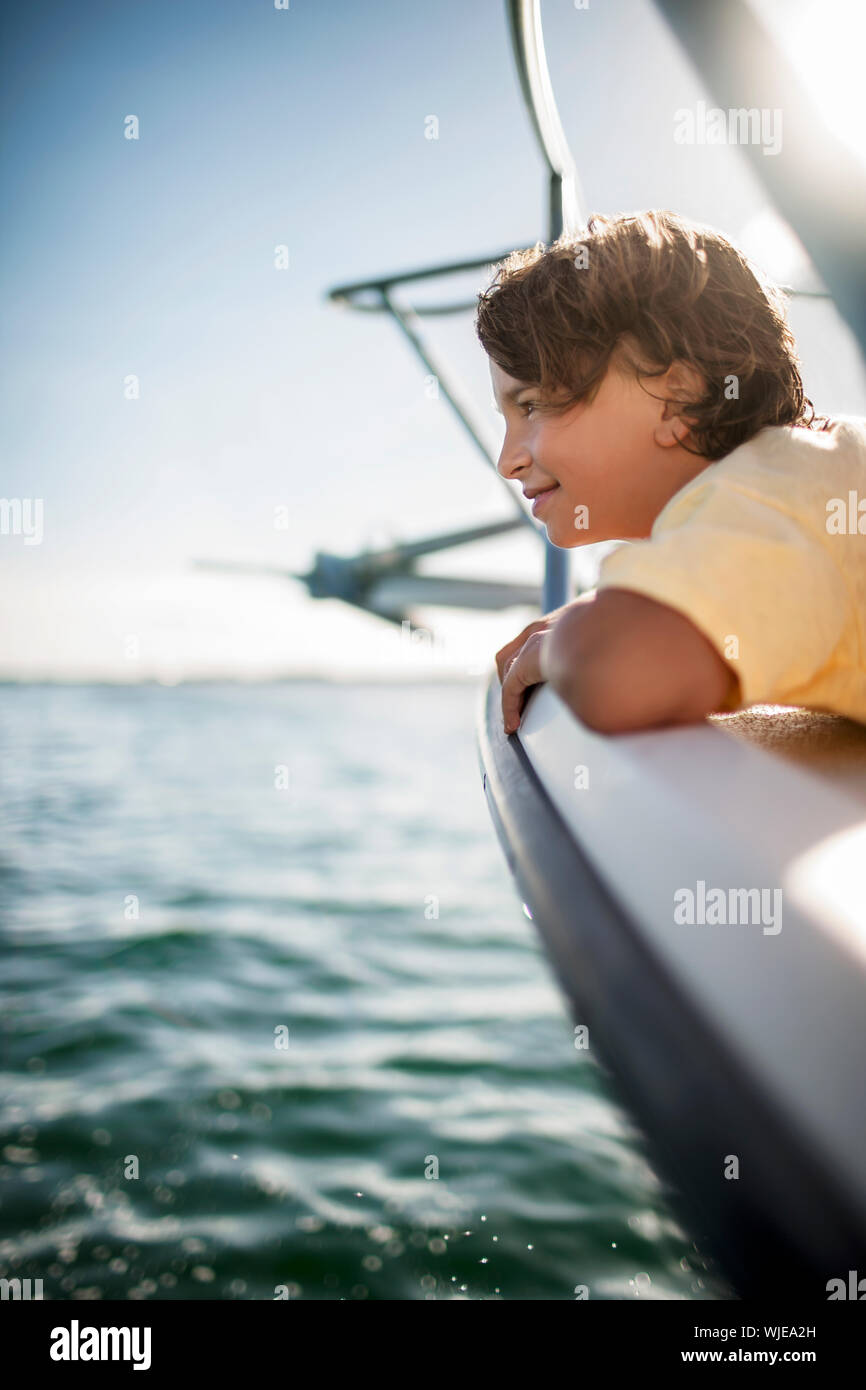 Young boy smiles happily as he goes sailing on the tropical ocean Stock ...