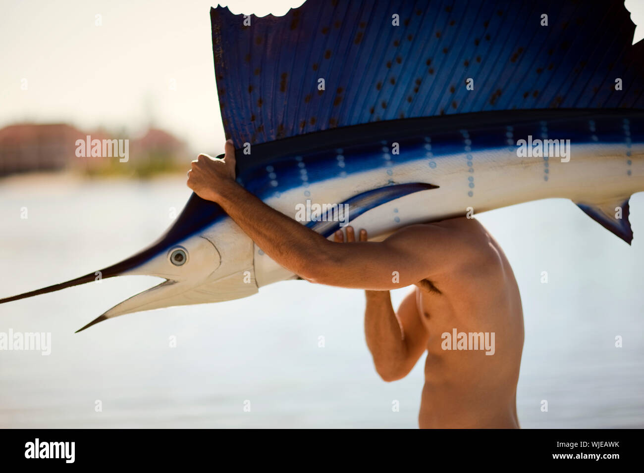 Mid adult man carrying an oversized plastic fish Stock Photo - Alamy