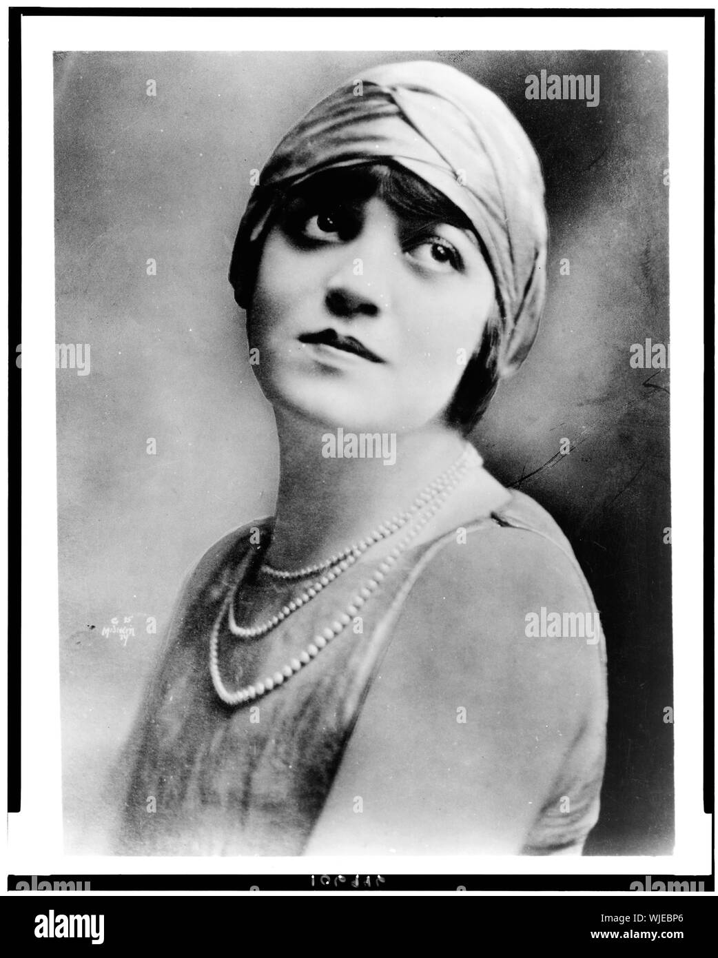 Head-and-shoulders portrait of a woman, facing forward, looking up to ...