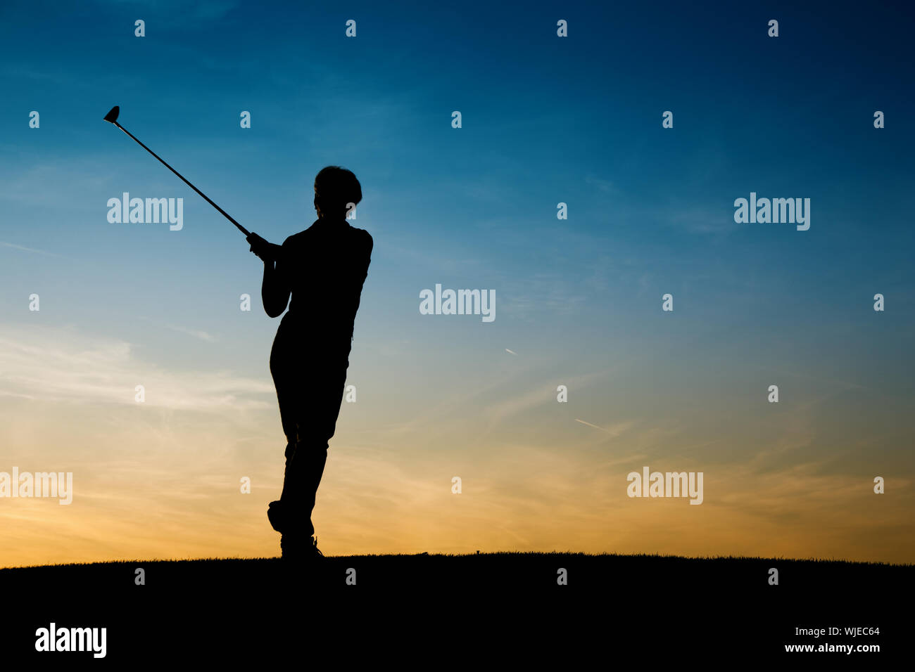 Senior female golf player at sunset Stock Photo - Alamy