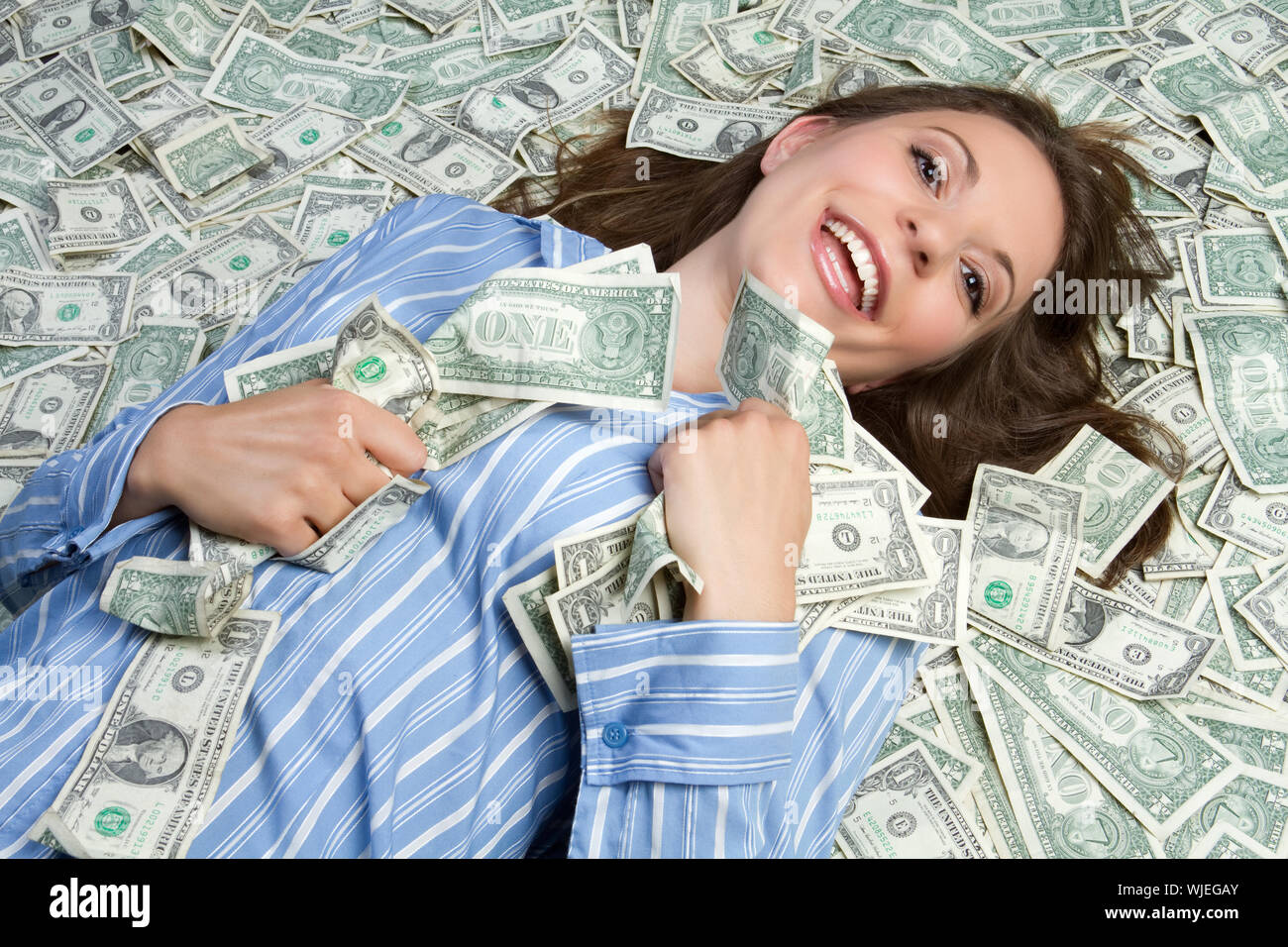 Beautiful woman laying in money Stock Photo - Alamy