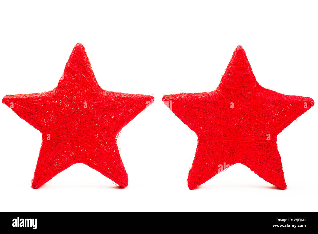 two red thread stars standing on white background Stock Photo - Alamy