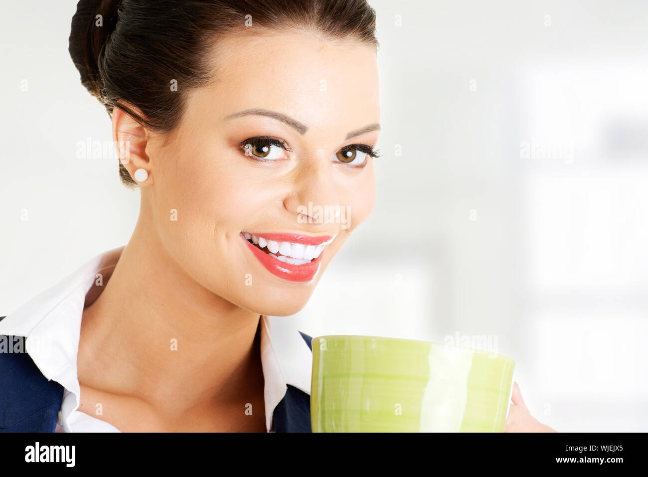 Smiling businesswoman having coffee / tea break isolated on white ...
