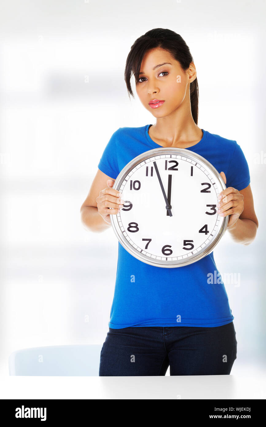 Portrait of shocked woman with clock over white background Stock Photo ...