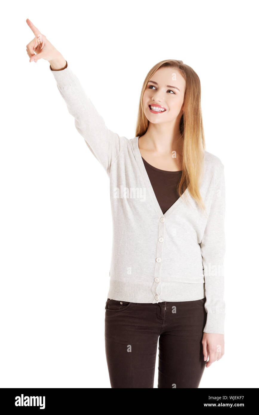 Beautiful casual woman is pointing up and advertising. Isolated on ...