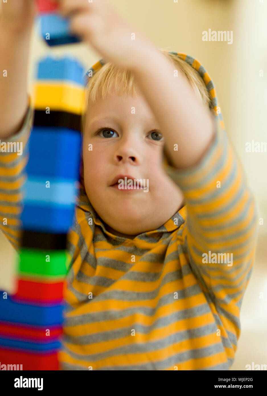 Boy building a big lego stack Stock Photo - Alamy