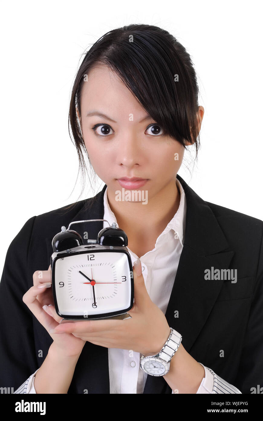 Young business girl holding one alarm clock and stare at you on white ...