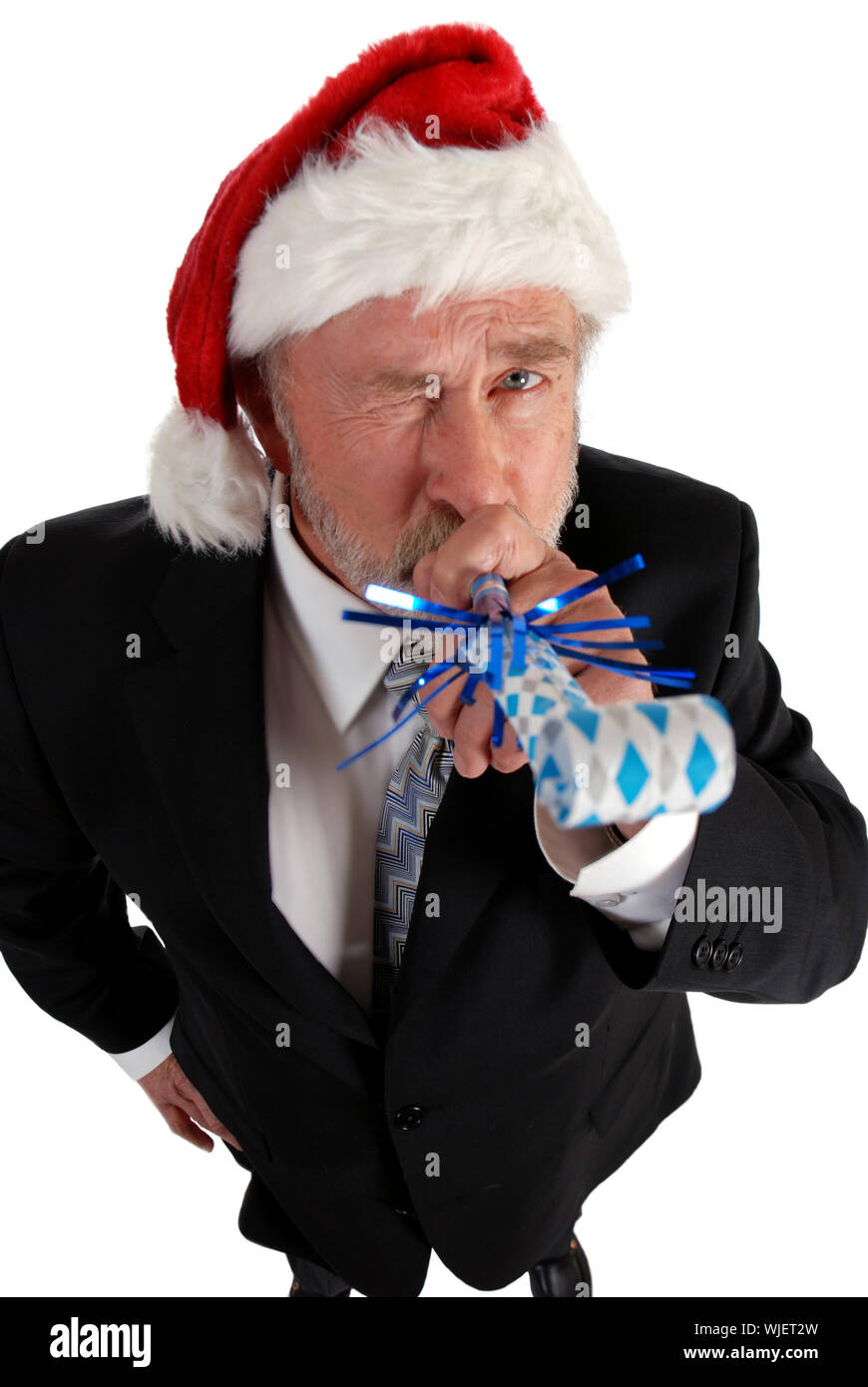 Business man in santa hat blowing party blower Stock Photo - Alamy