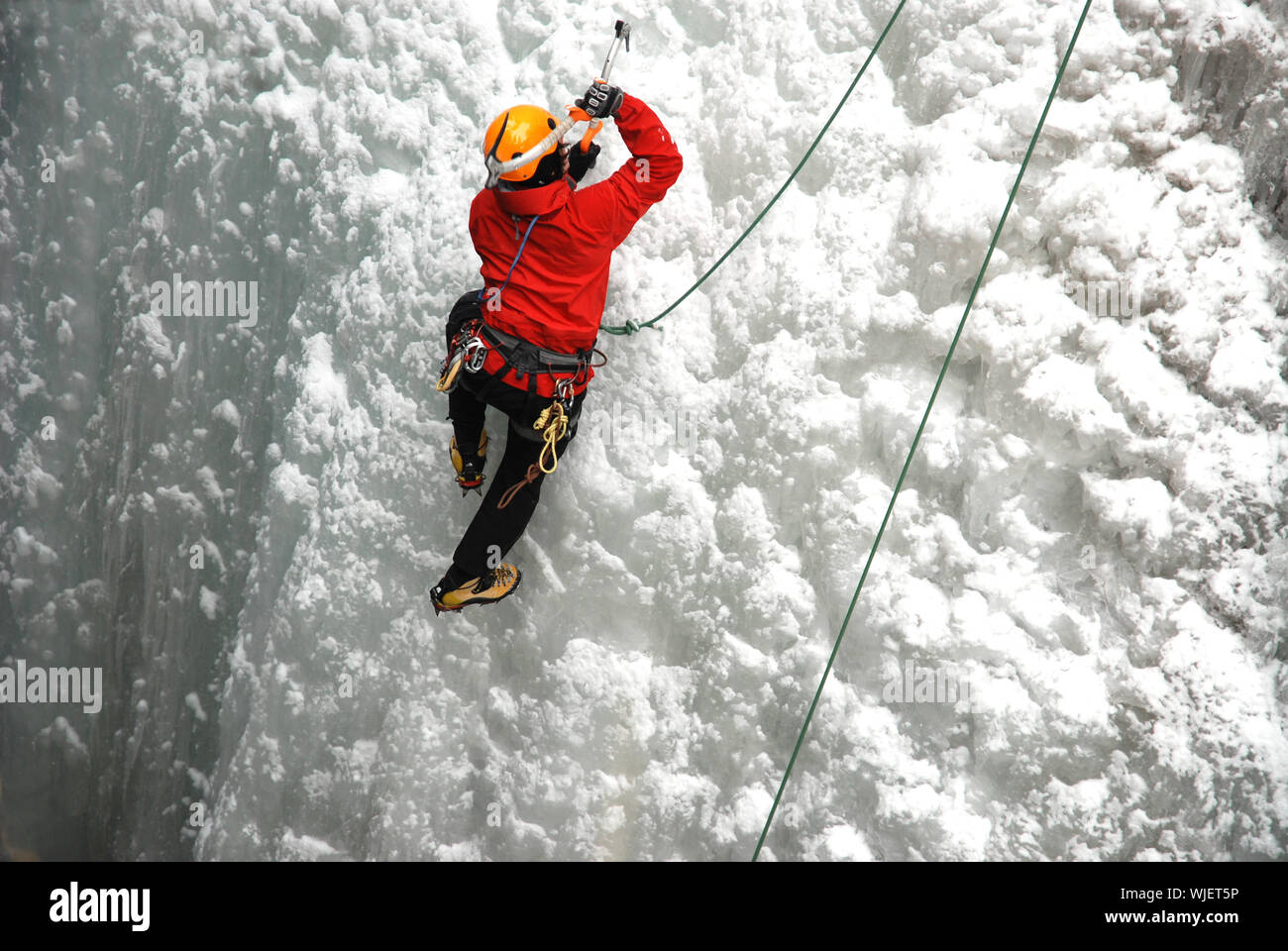 An Ice Climber going up a frozen waterfall Stock Photo - Alamy