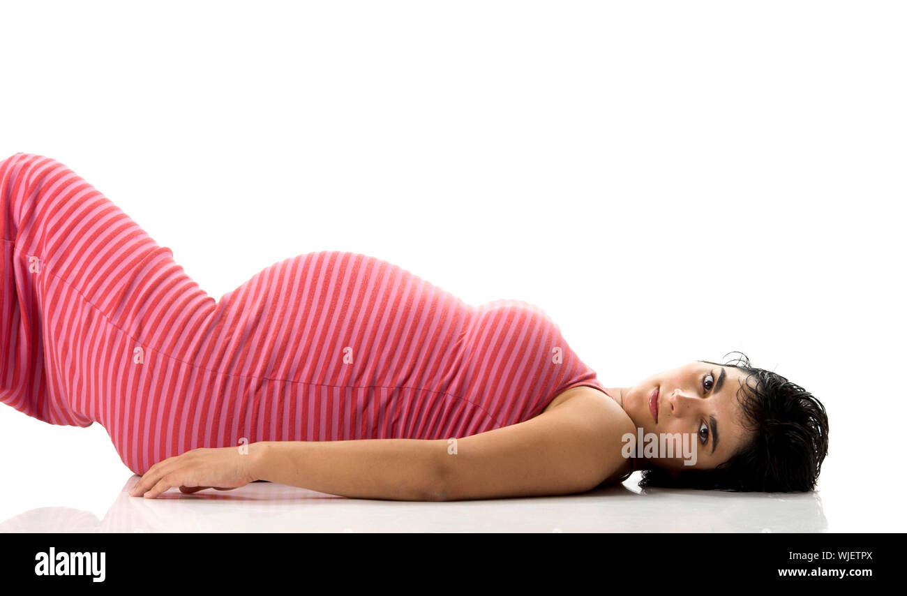 Beautiful pregnant woman lying down on the floor and isolated on white ...
