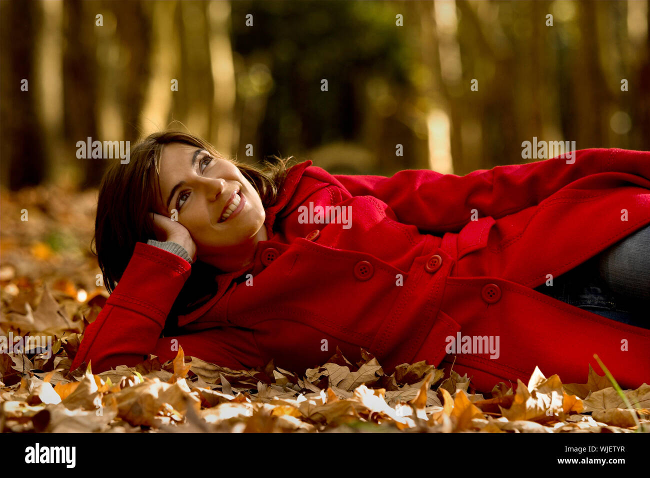 Portrait of a beautiful young woman relaxing in a Autumn background ...