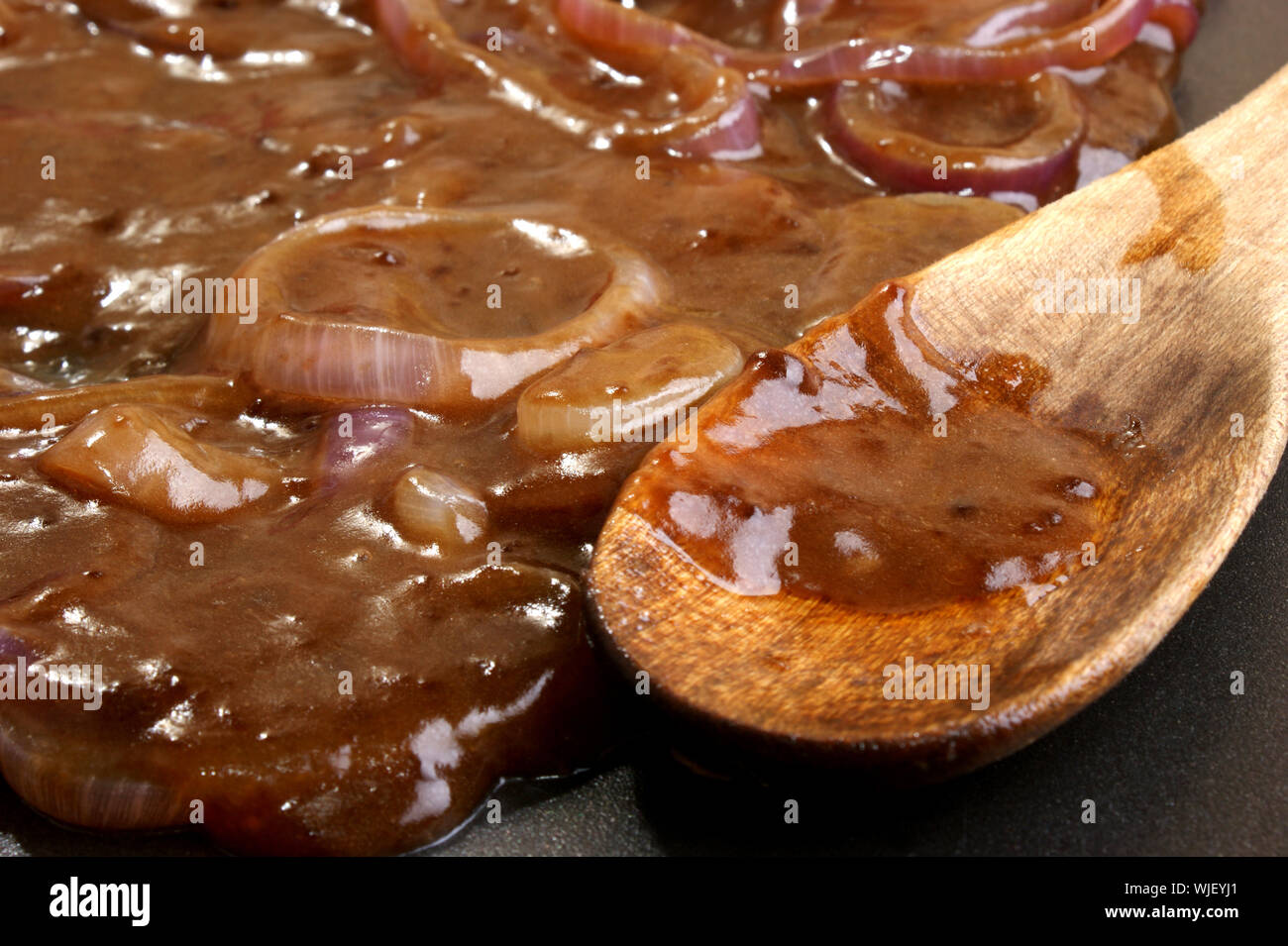 some onion rings with gravy in a pan Stock Photo - Alamy