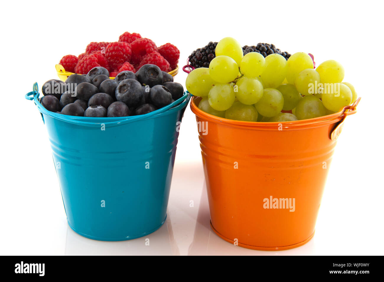 colorful buckets with fresh summer fruit isolated over white Stock ...