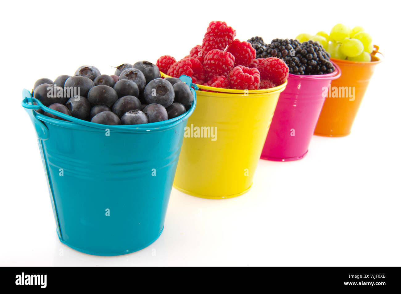 colorful buckets with fresh summer fruit isolated over white Stock ...