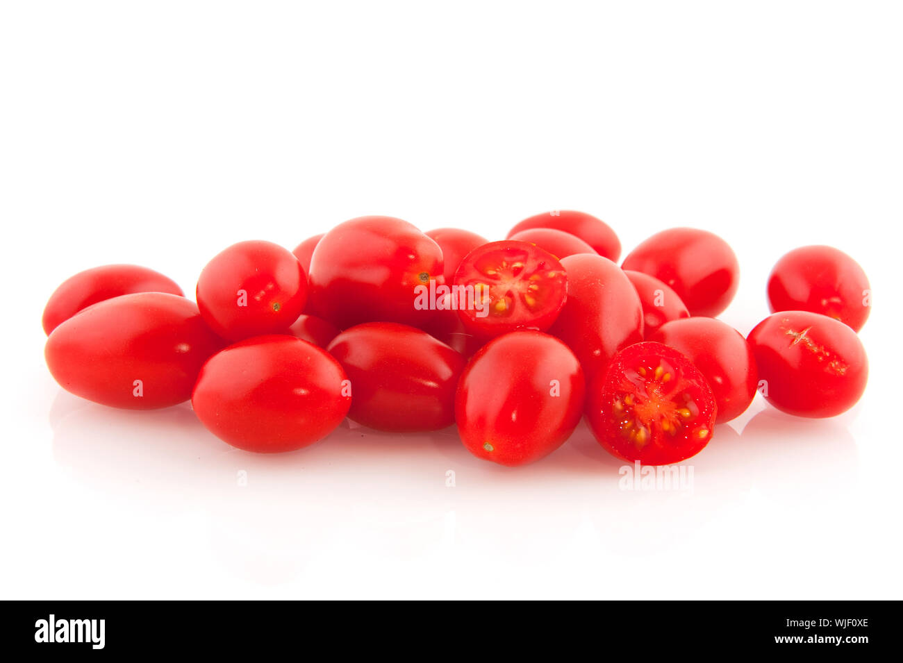 Many sweet little red tomatoes with one open Stock Photo - Alamy