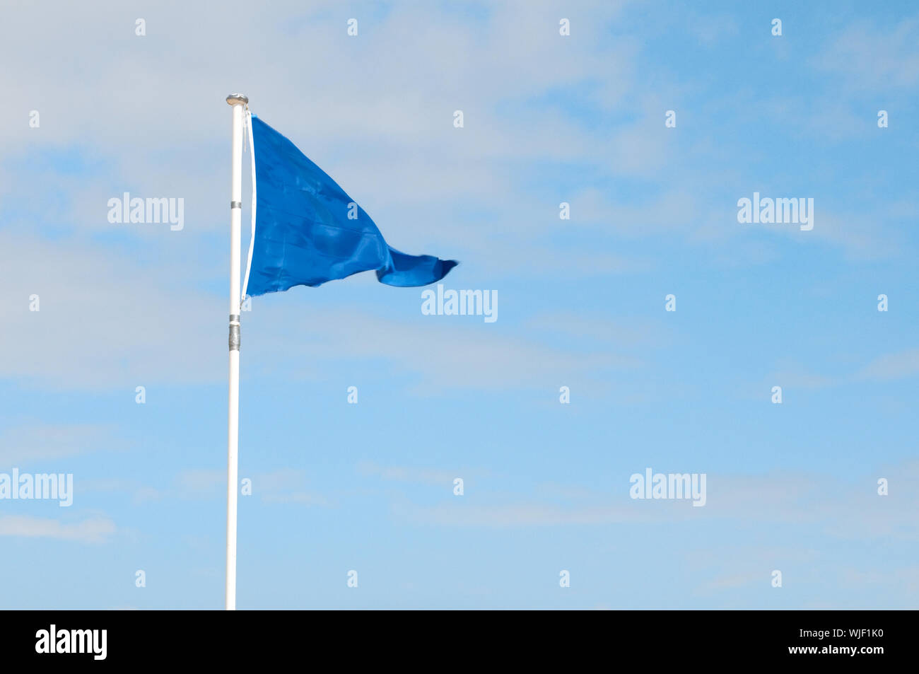 Blue flag as symbol for a clean beach Stock Photo - Alamy