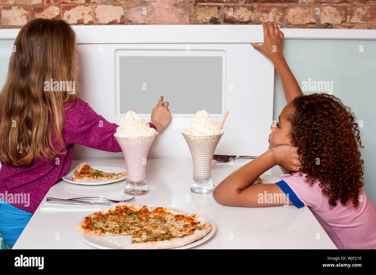 Little girls ordering pizza online in restaurant Stock Photo - Alamy