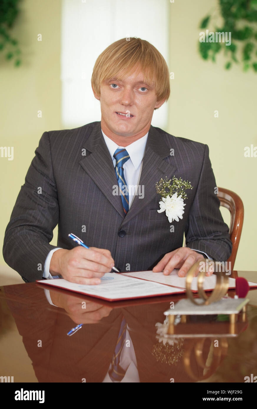 The groom puts his signature on the registration document Stock Photo ...