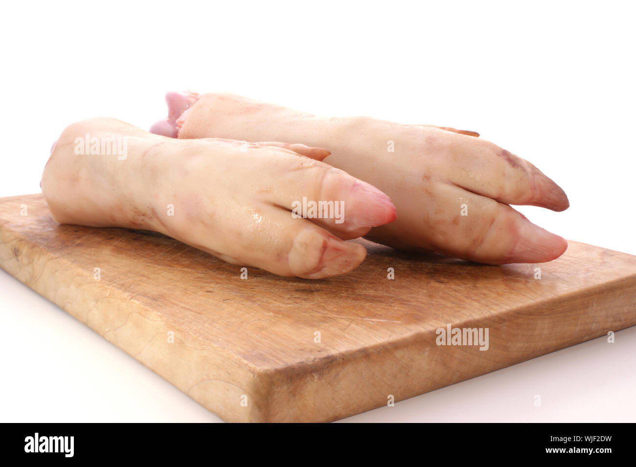two fresh pig trotter on timber board Stock Photo - Alamy