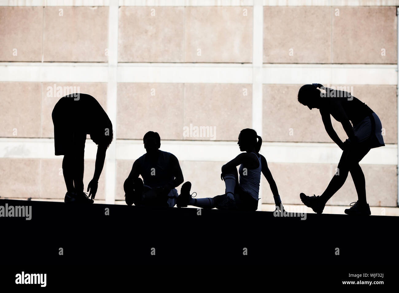Group of runners stretching before race Stock Photo - Alamy