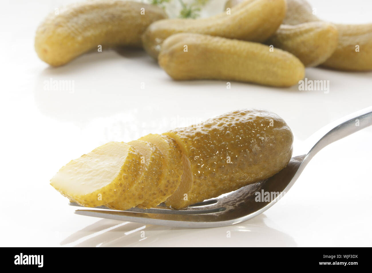 one gherkin cut into slices on a fork Stock Photo - Alamy