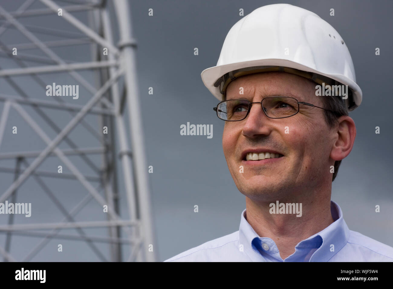 Smiling engineer with helmet on construction site Stock Photo - Alamy