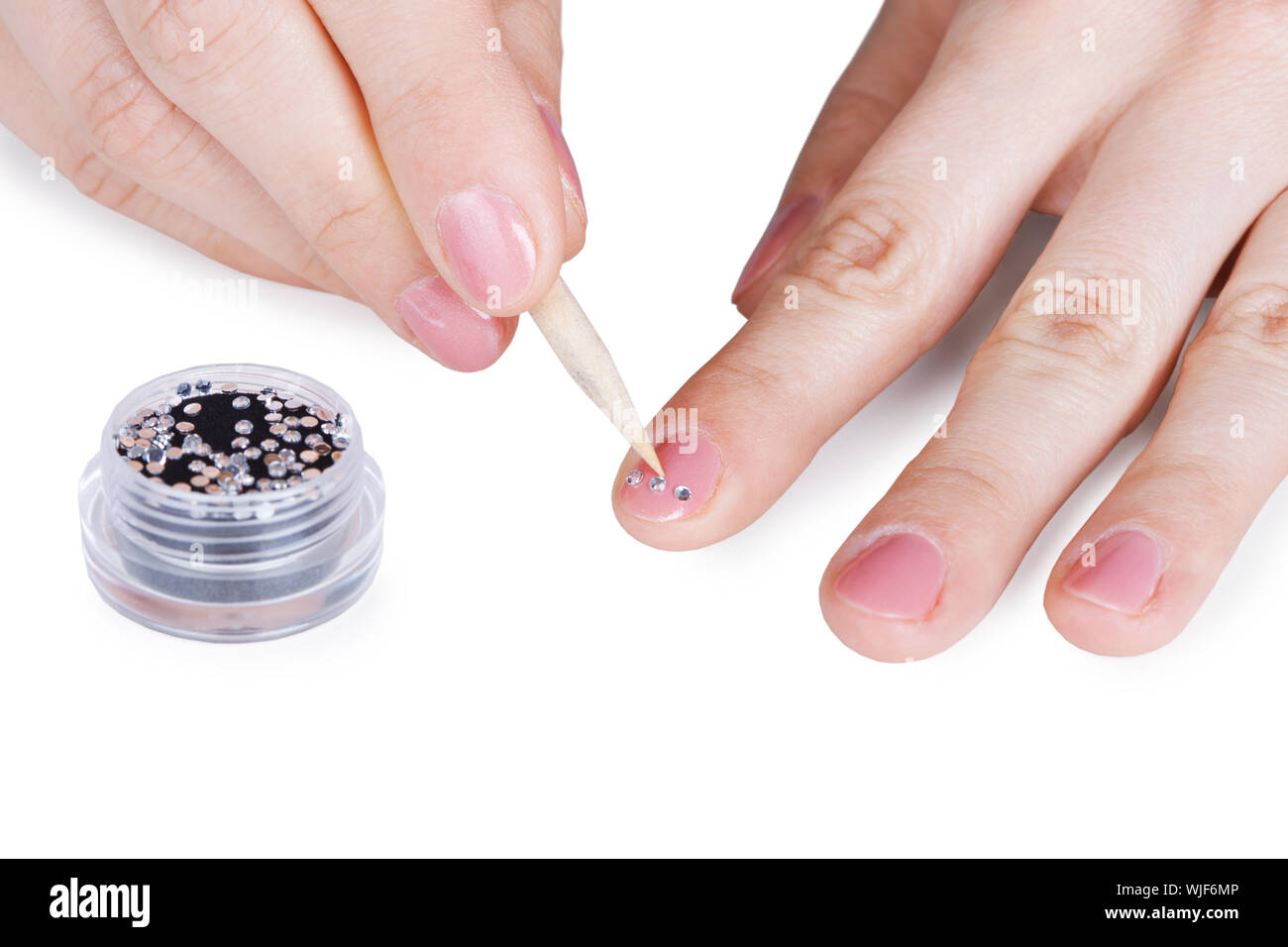 Female hands on the white. Gluing a paste on a nail Stock Photo - Alamy