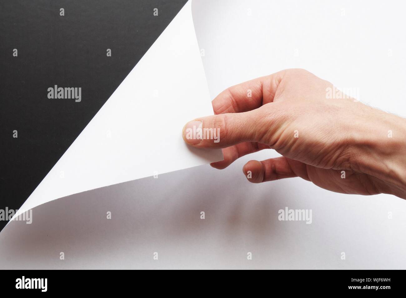 hand turning over blank sheet of paper Stock Photo - Alamy