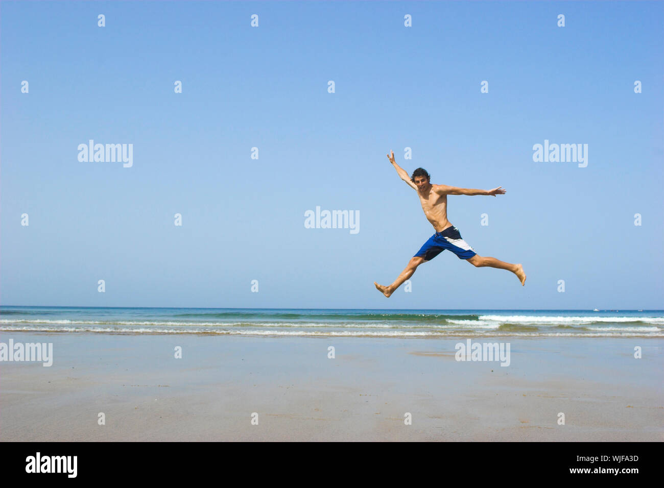 Picture of a young man jumping on the beach Stock Photo - Alamy