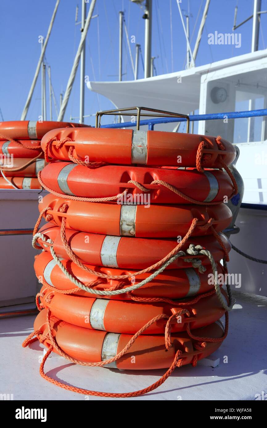 Stacked orange rescue round buoy, sea marine lifesaver Stock Photo - Alamy