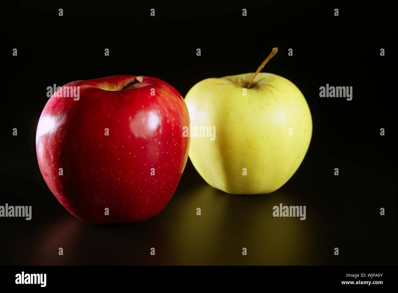 Apple fruit, pair of red and yellow fruits over black background Stock ...