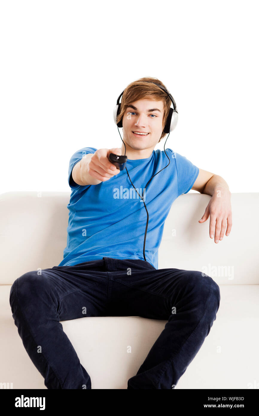 Young man sitting on the couch using a remote control Stock Photo - Alamy