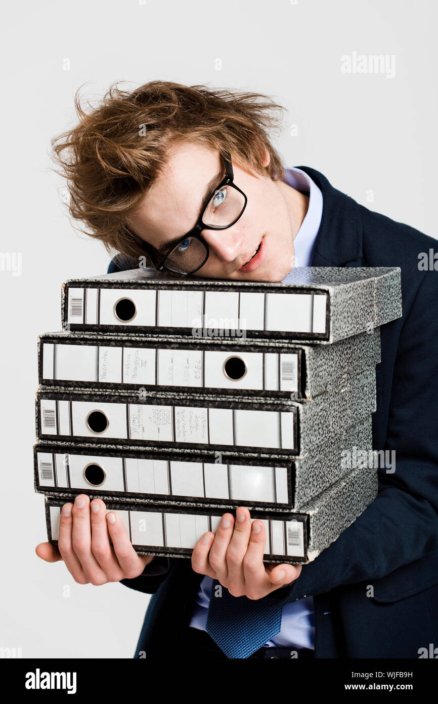Young business man with nerd glasses and carrying a bunch of folders ...