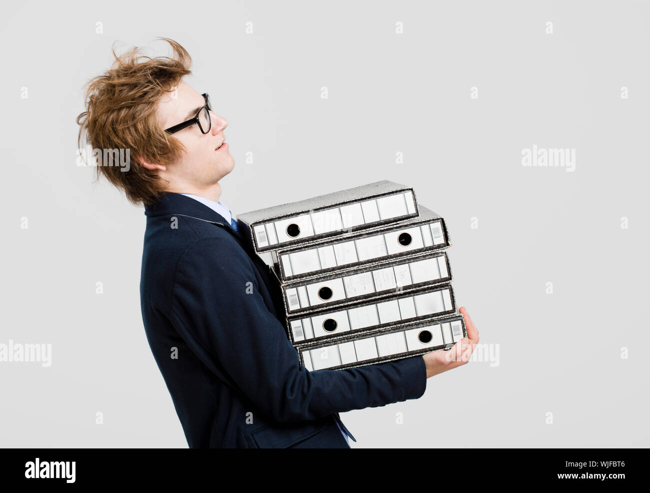 Young business man with nerd glasses and carrying a bunch of folders ...