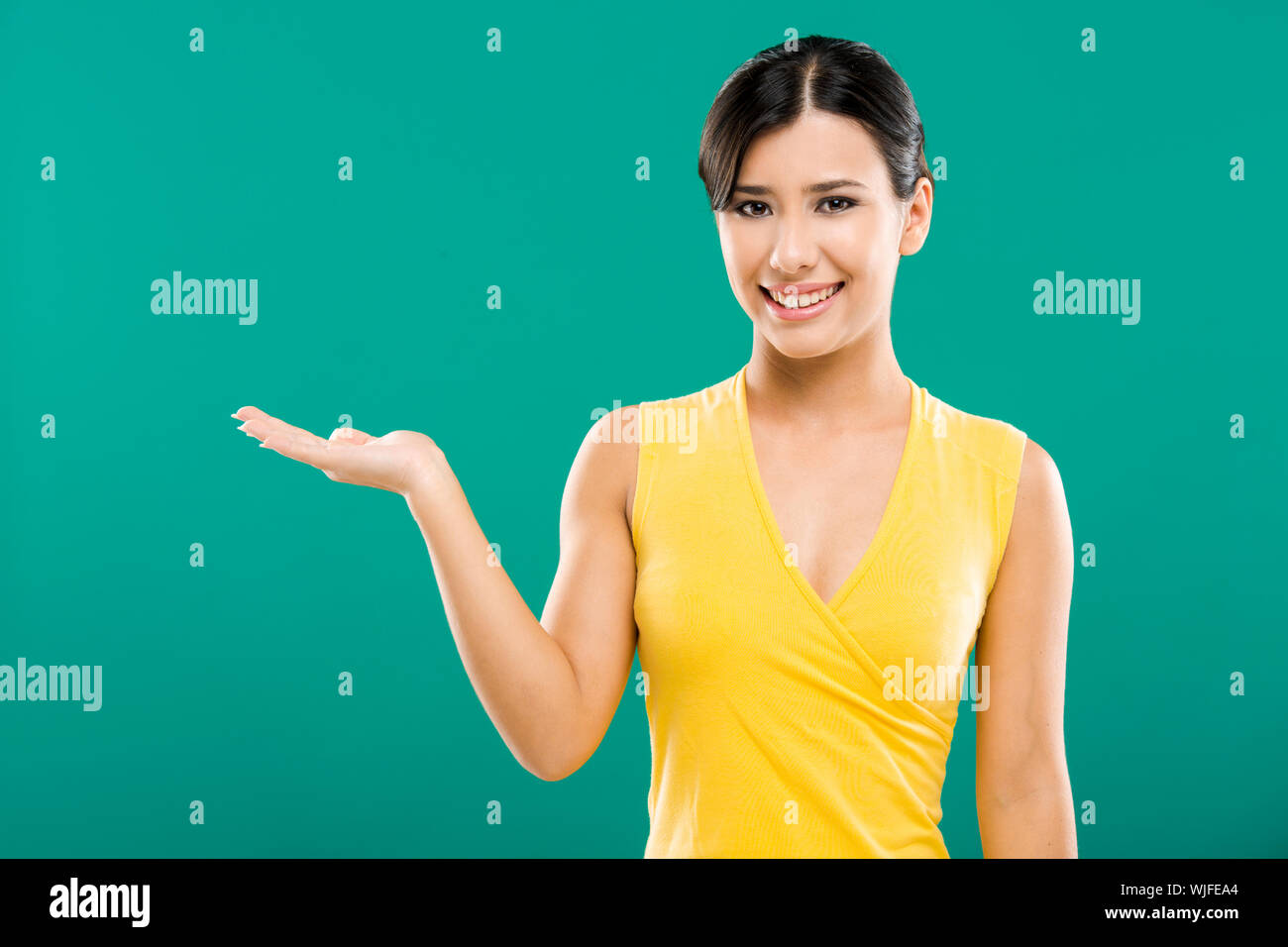 Beautiful asian woman showing the palm of the right hand, over a green ...