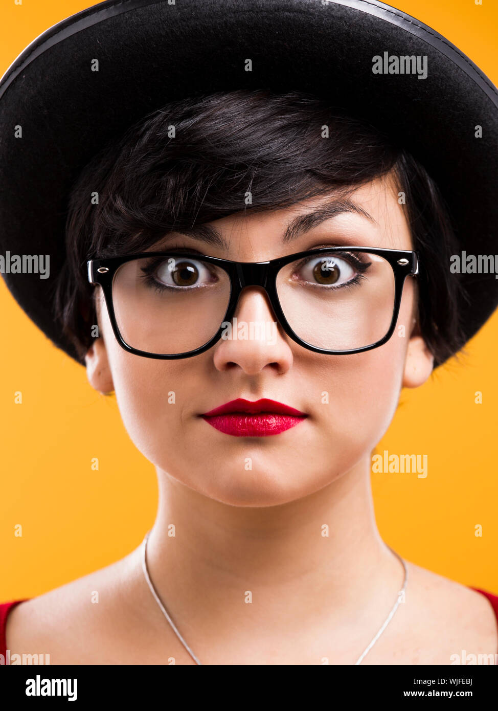 Beautiful girl with a astonished expression, wearing a hat and nerd ...