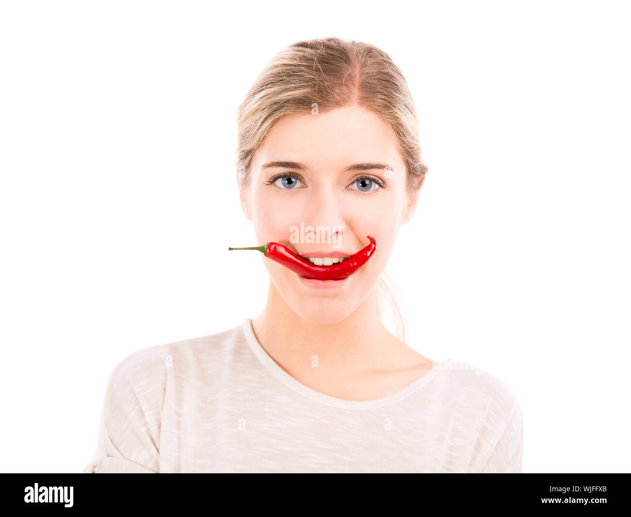 Beautiful girl biting a red chilli pepper, isolated over a white ...
